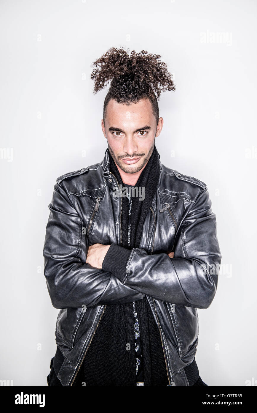 A young mixed race man posing in a studio looking cool Stock Photo - Alamy
