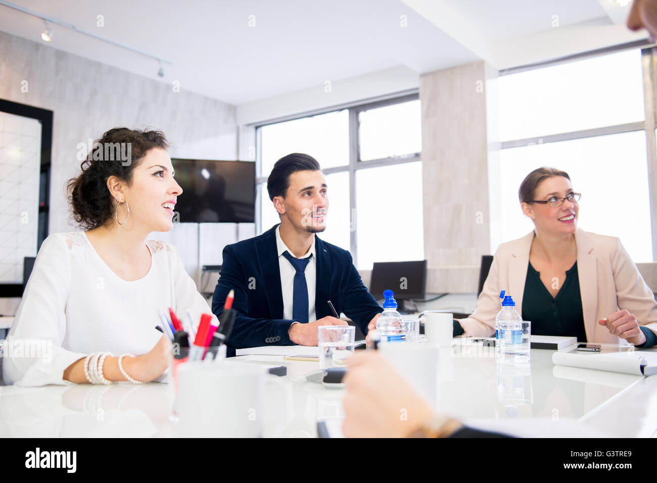 Professional people sitting in an office environment having a ...