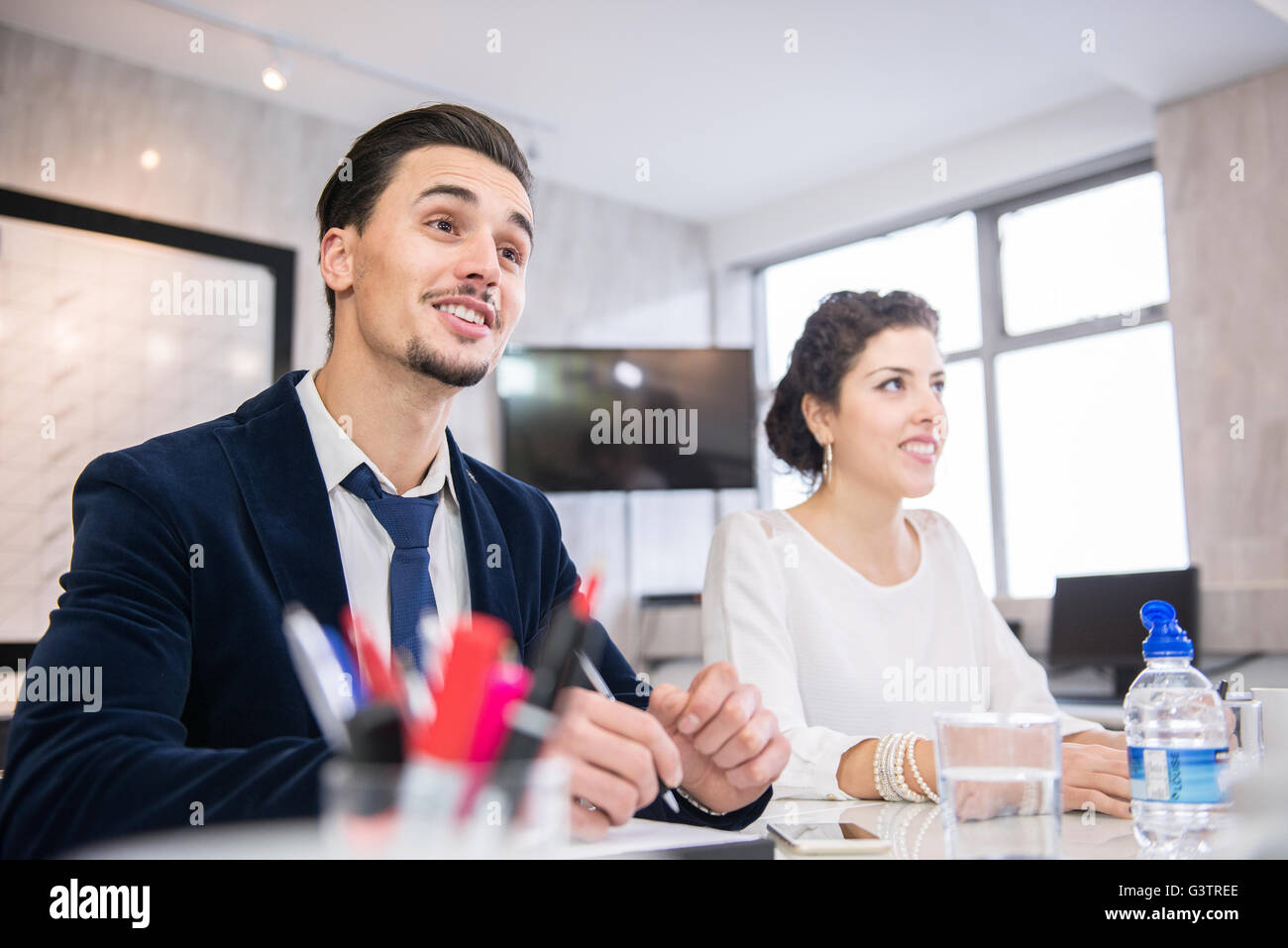 Two professional people sitting in an office environment having a ...