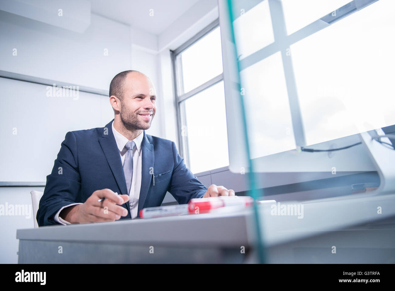 A professional man sitting in front of a computer in an office ...