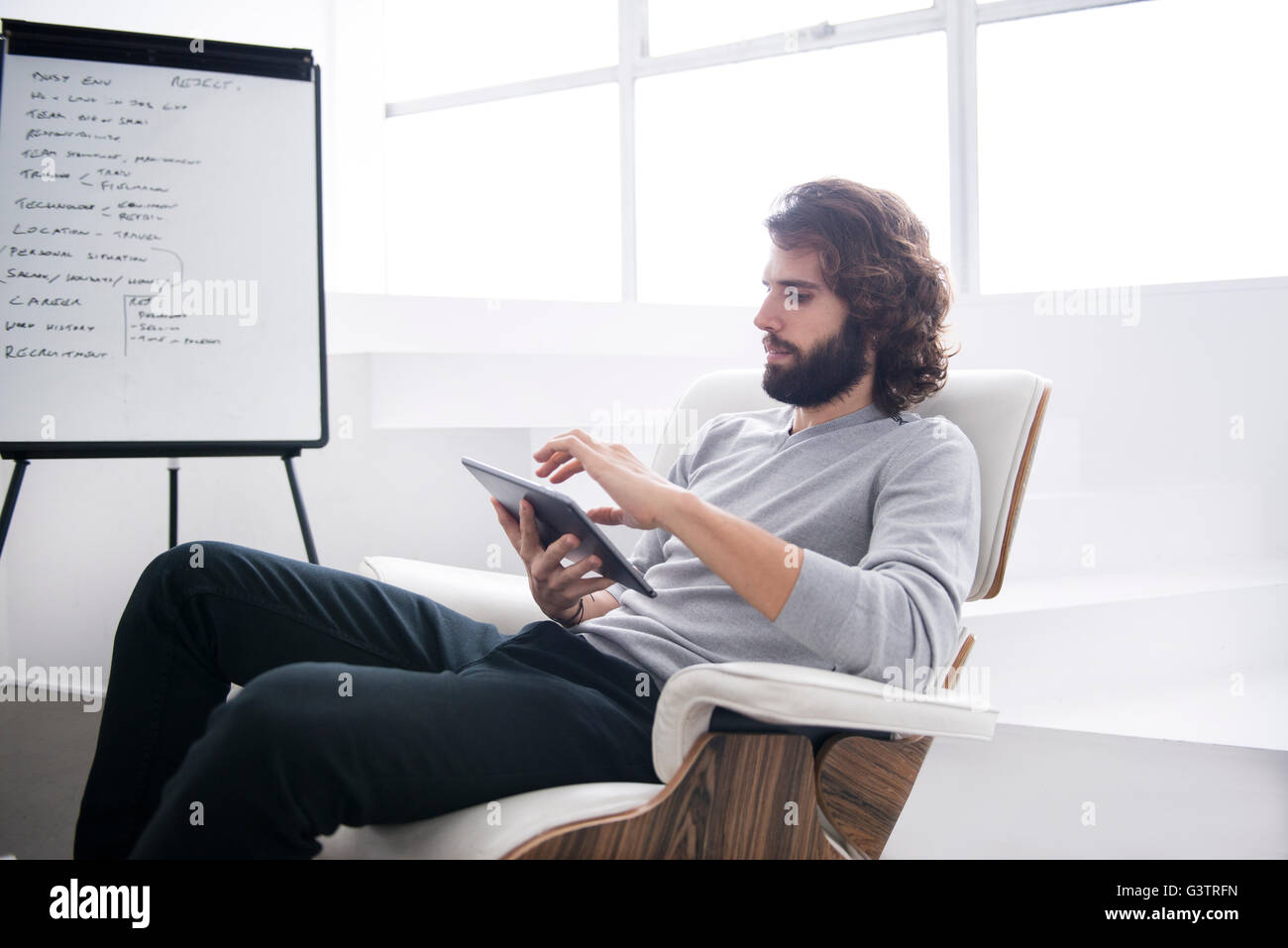 A professional man looking at a tablet computer in an office ...