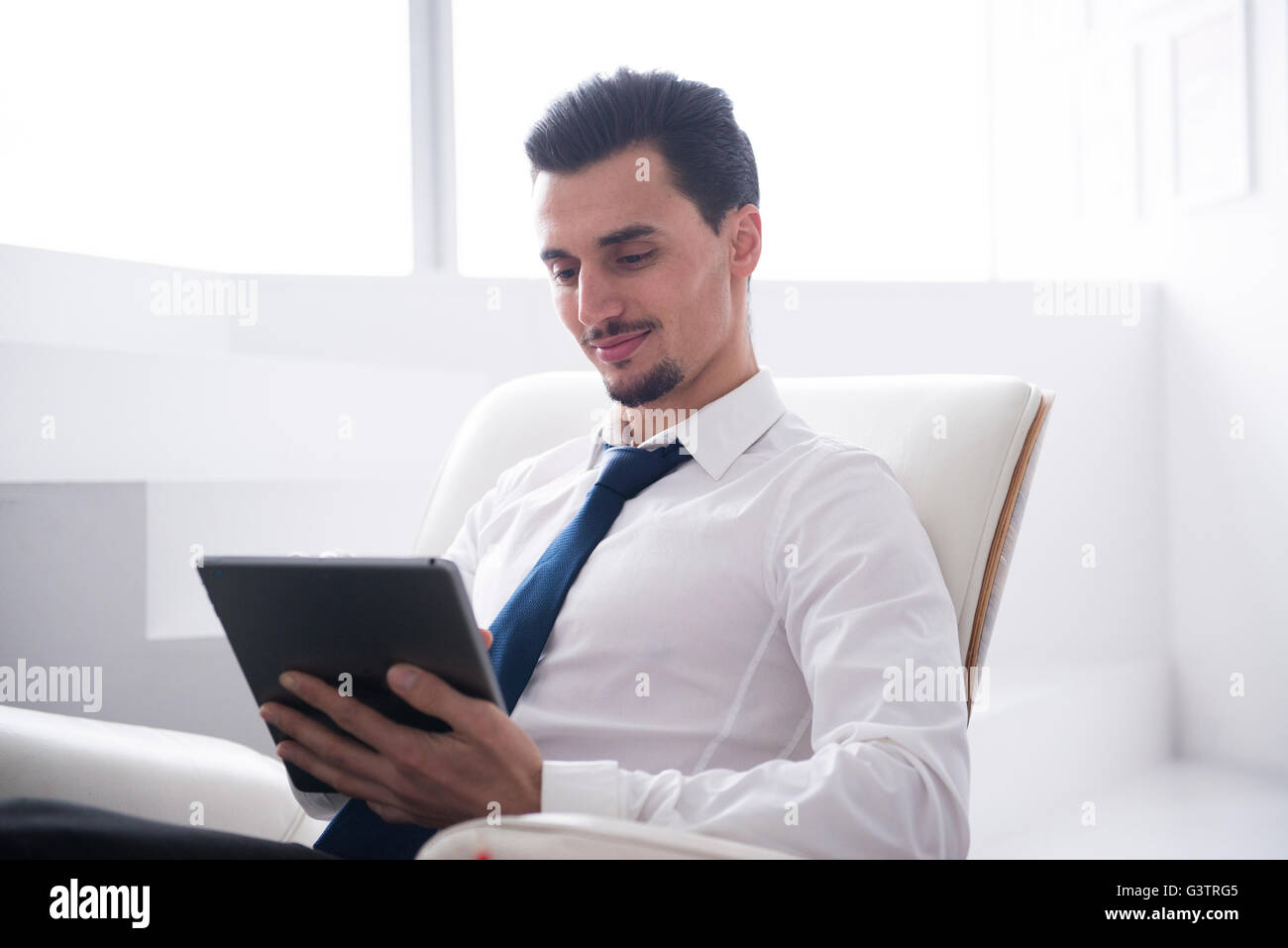 A professional man looking at a tablet computer in an office ...