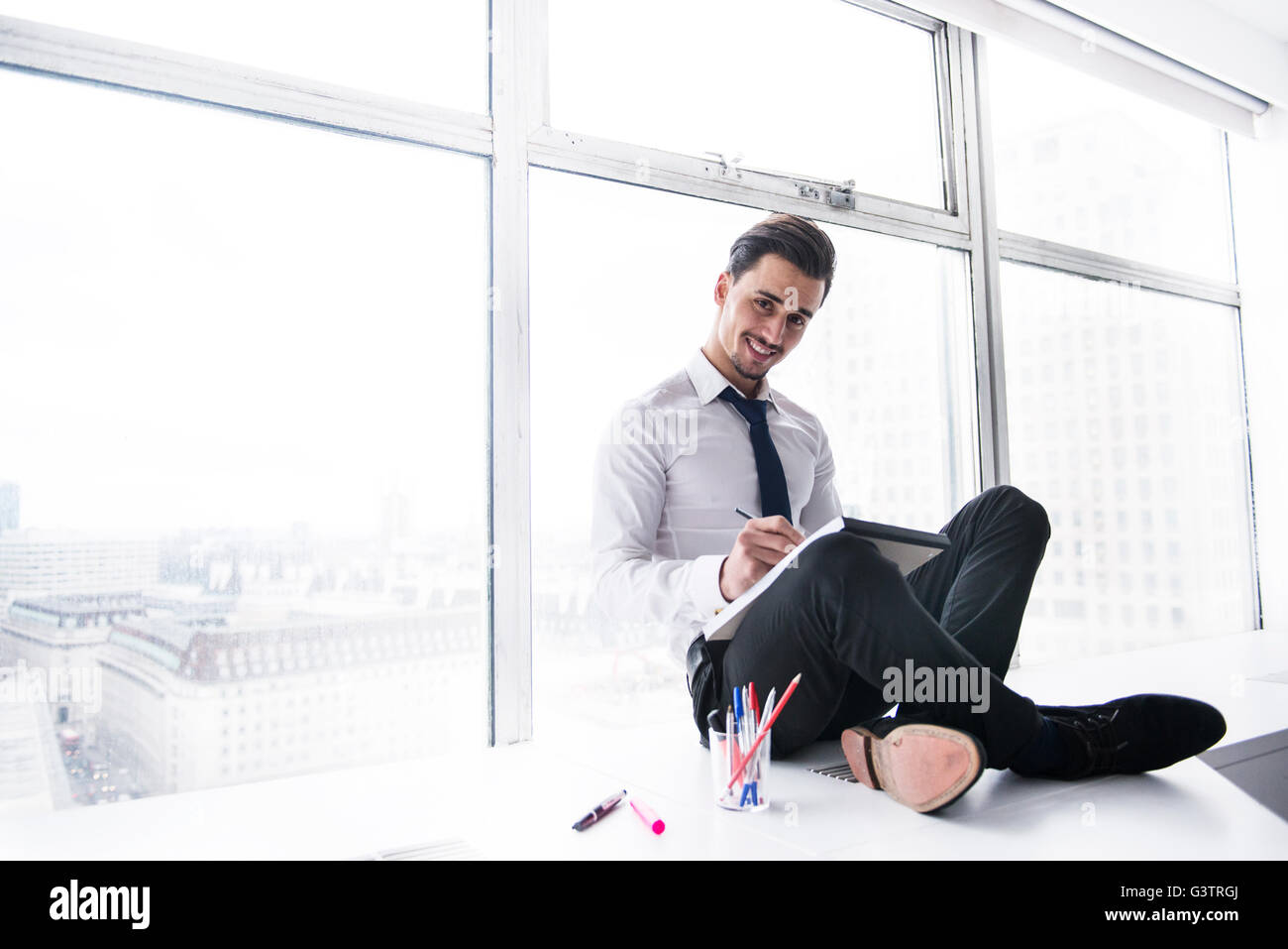 A professional man looking at a tablet computer in an office ...