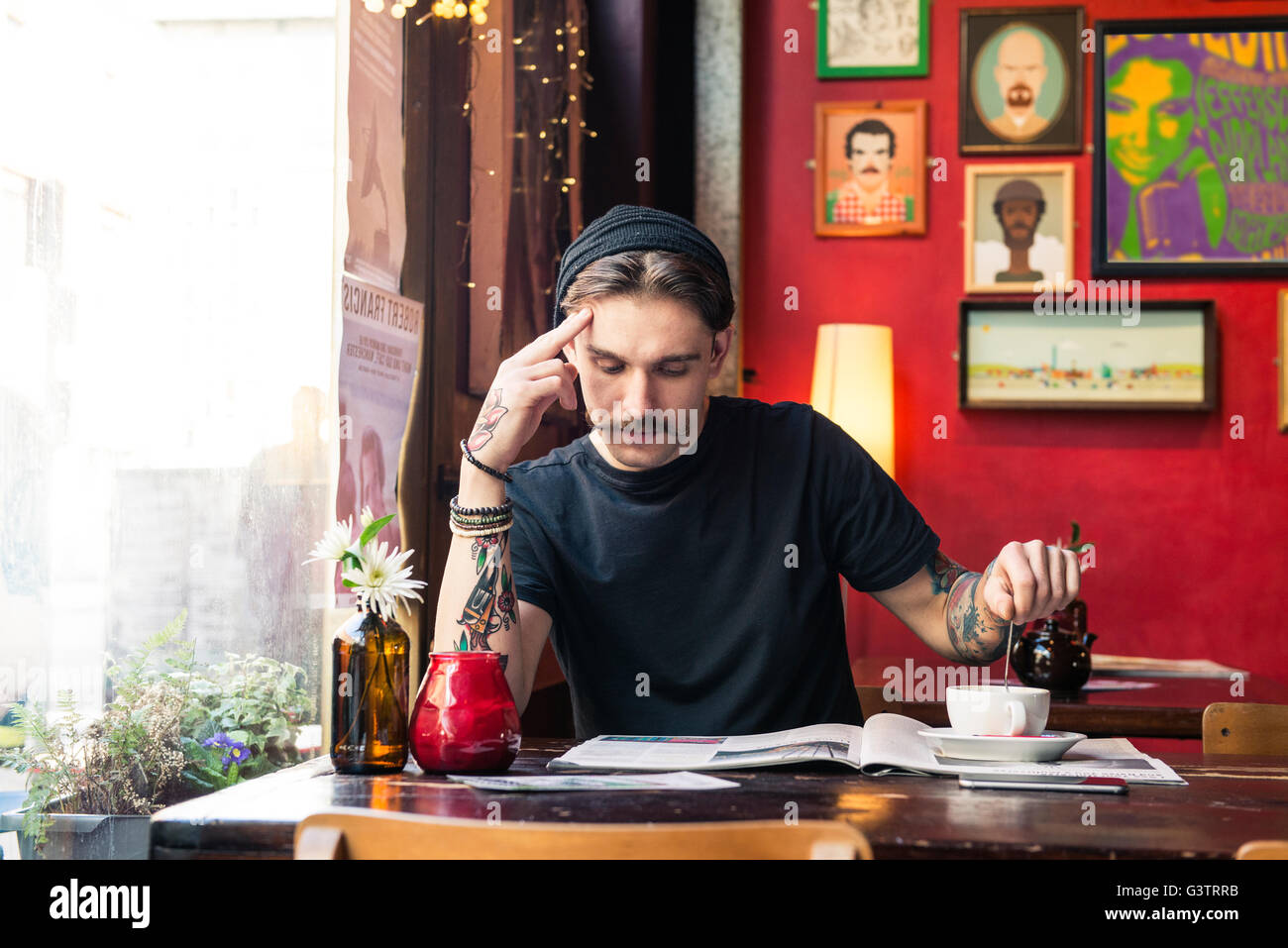 A young man sitting at a table in a coffee shop in Manchester Stock ...