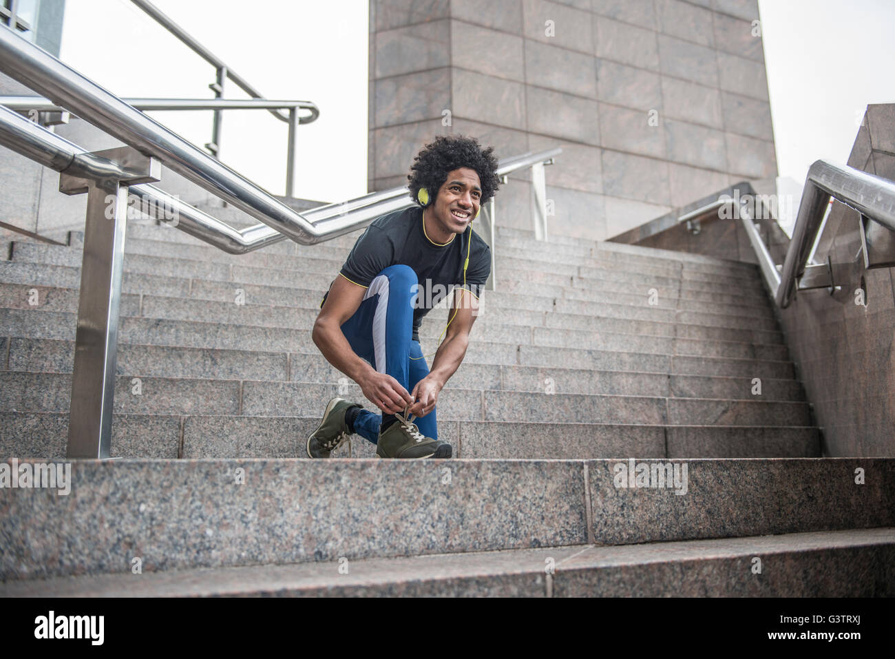 A young man limbering up for a jog along the South Bank in London Stock ...