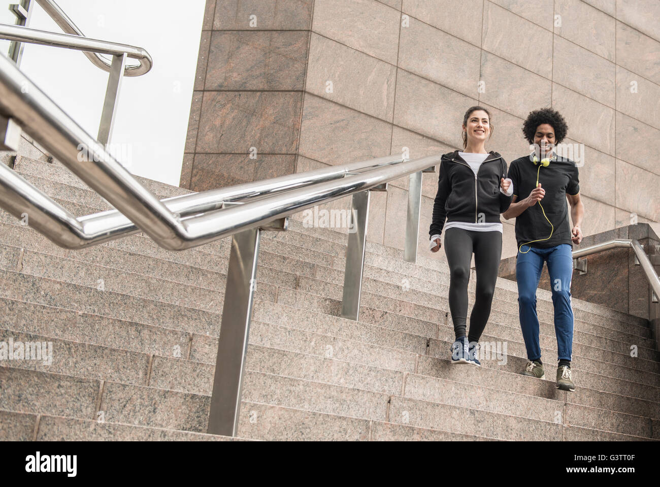 A young couple limbering up before a jog along the South Bank in London ...