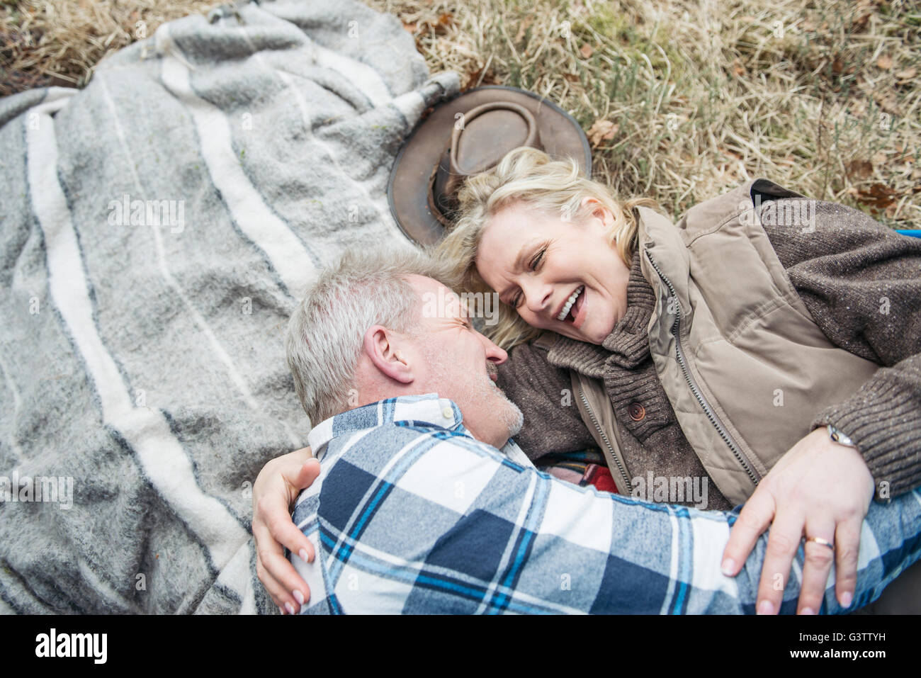 Senior couple cuddling together on a blanket at their campsite Stock ...
