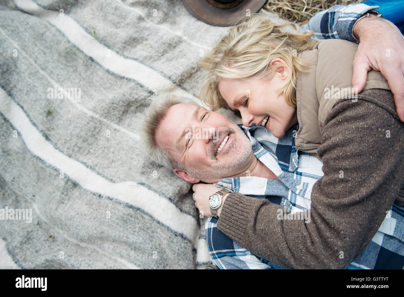 Senior couple cuddling together on a blanket at their campsite Stock ...