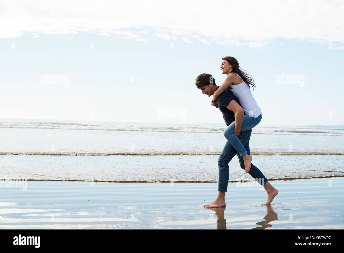 Couple on beach piggy back hi-res stock photography and images - Alamy