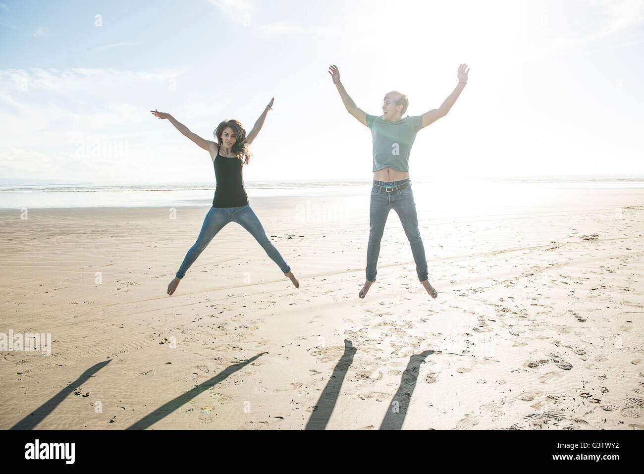 Woman star jump beach hi-res stock photography and images - Alamy