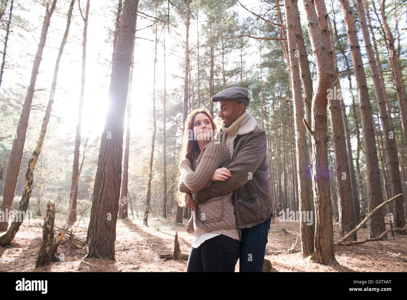 A young couple cuddling on a forest walk in Autumn Stock Photo - Alamy