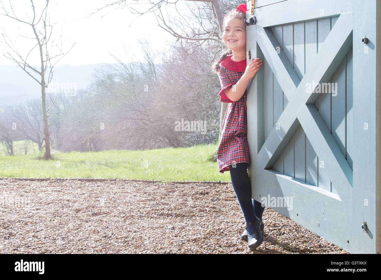 A Six Year Old Girl Standing At A Back Door Peeping Into A Kitchen