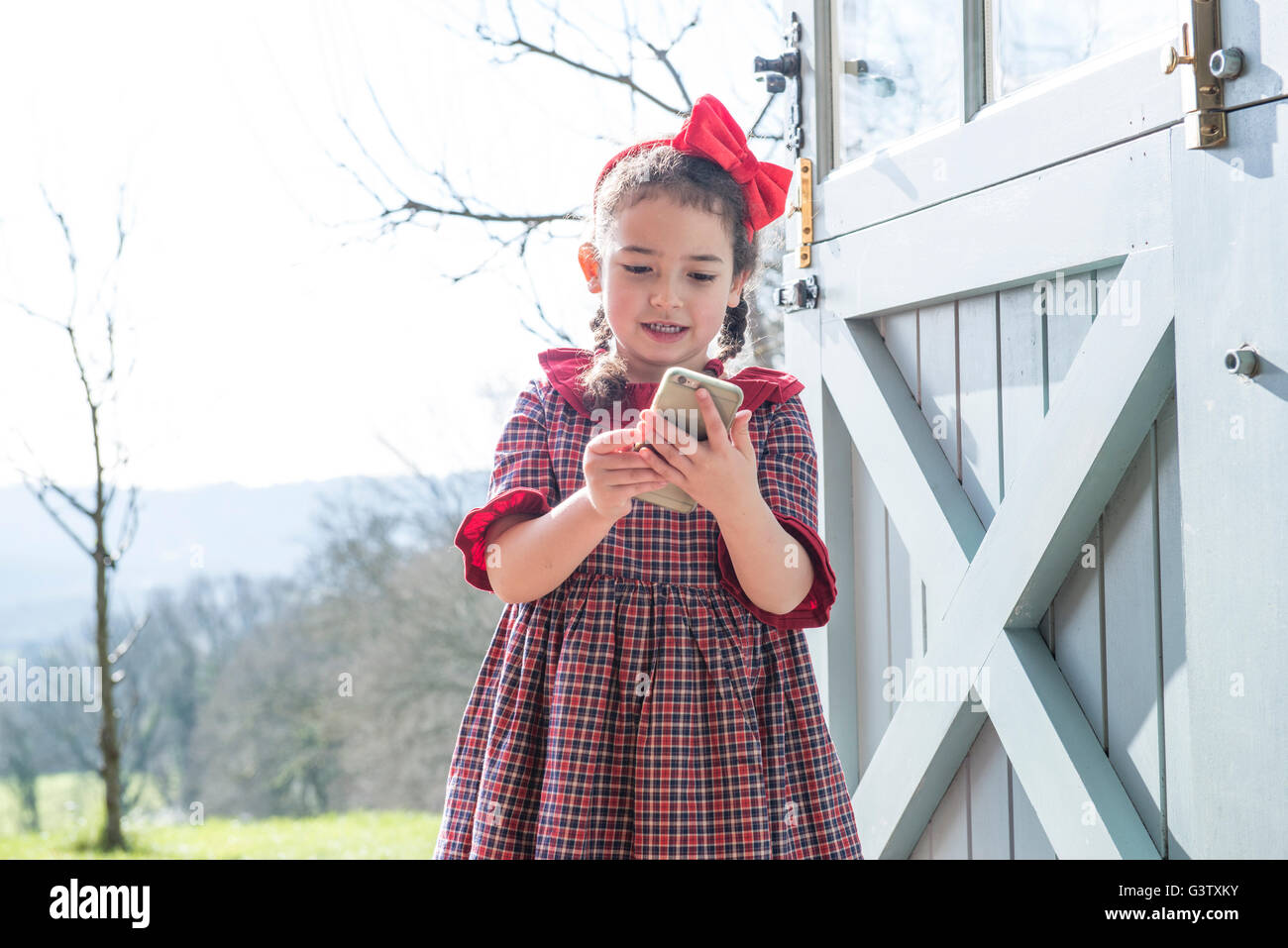 A Six Year Old Girl Standing At A Back Door Taking Pictures With A