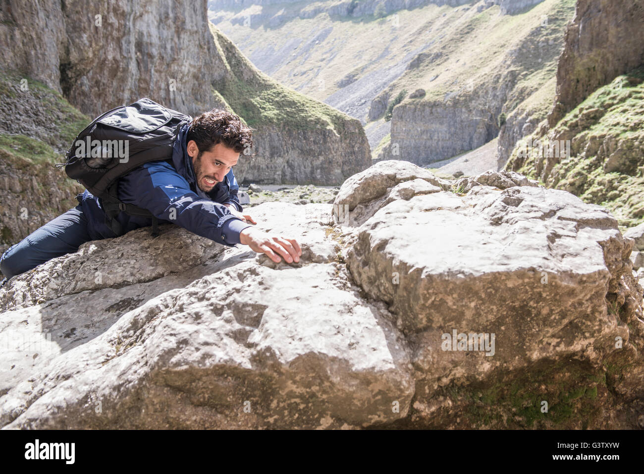 A mountaineer climbing over rocks in rugged terrain Stock Photo - Alamy