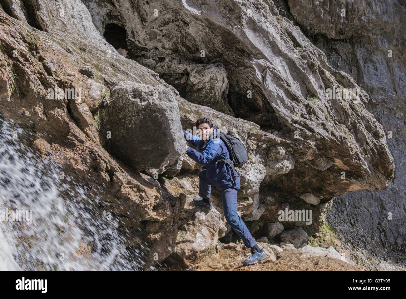 A mountaineer climbing over rocks in rugged terrain Stock Photo - Alamy