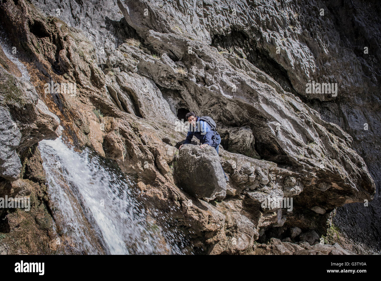A mountaineer climbing over rocks in rugged terrain Stock Photo - Alamy