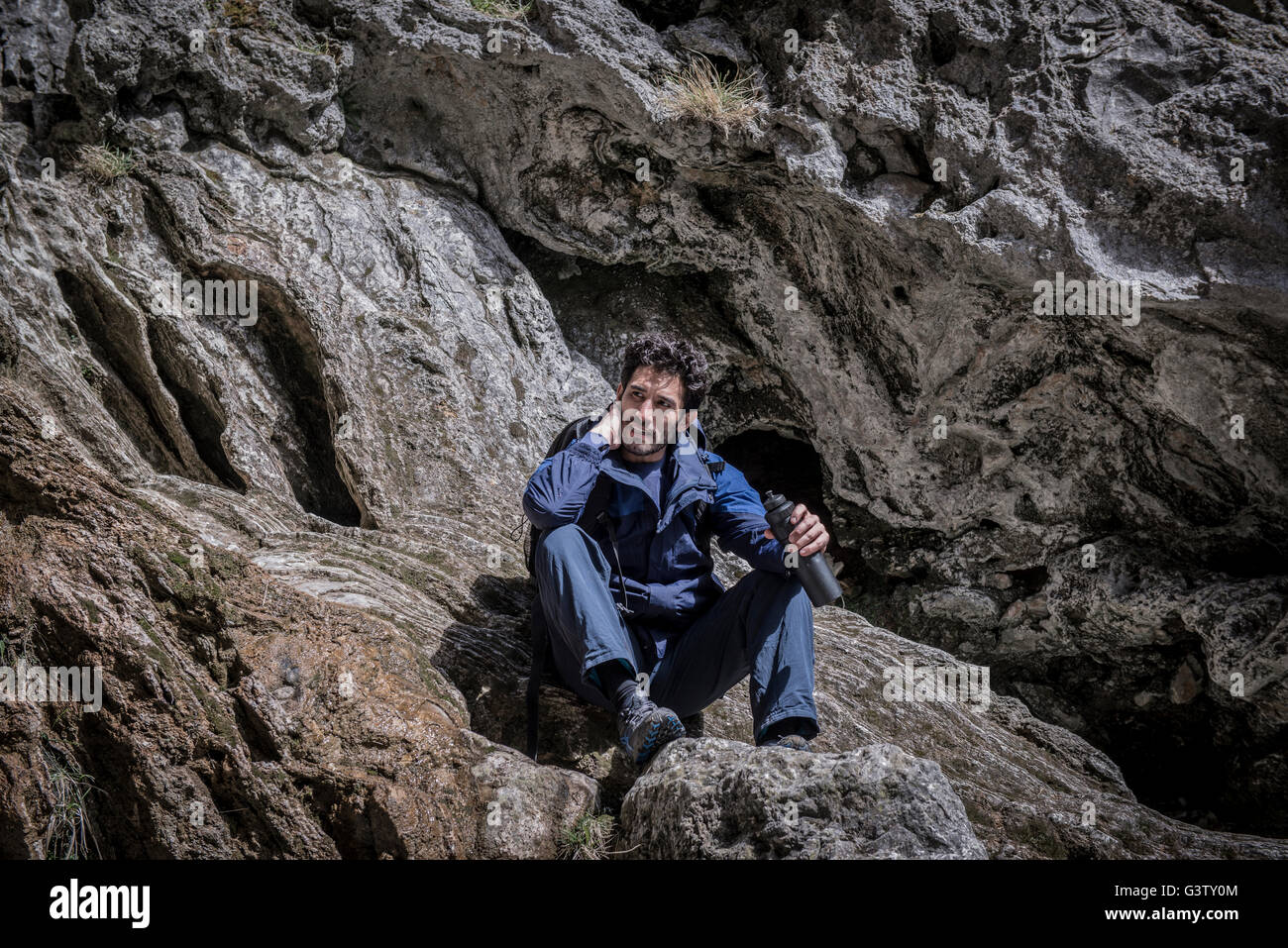A mountaineer climbing over rocks in rugged terrain Stock Photo - Alamy