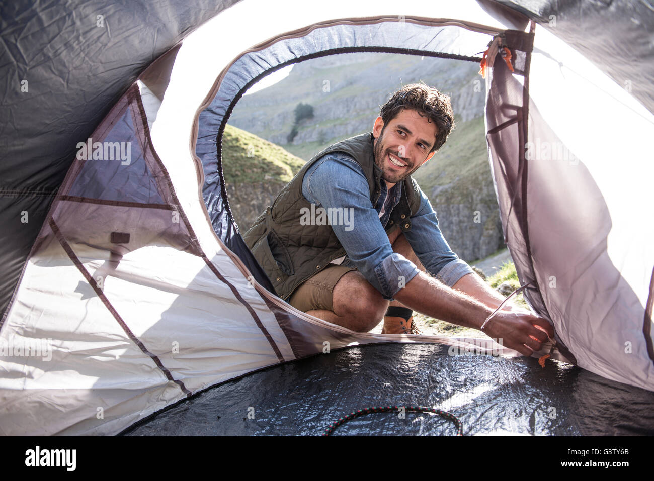 A mountaineer pitching his tent in rugged terrain Stock Photo - Alamy