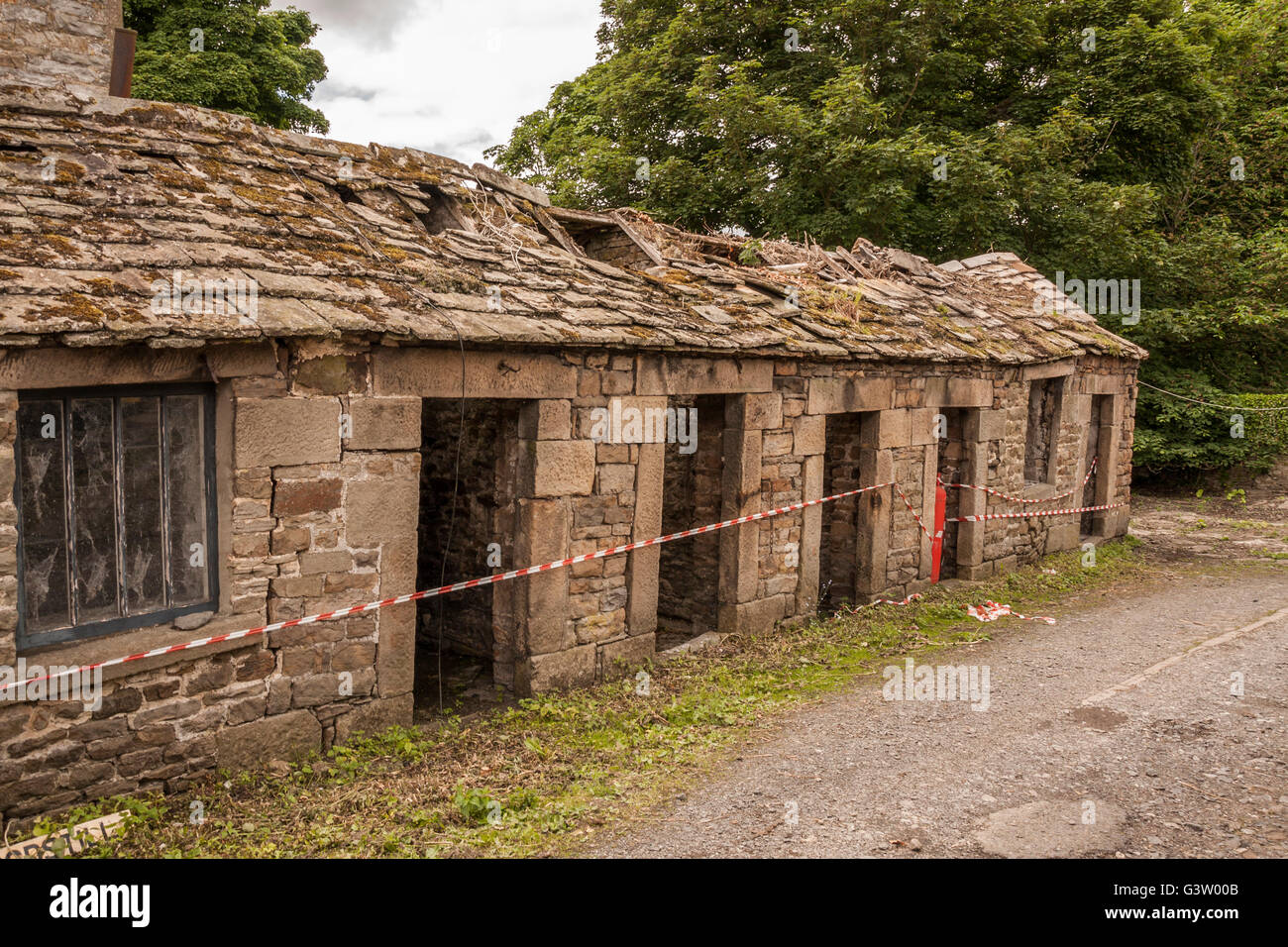 Dilapidated stone outhouse buildings cordoned off at the rear of the ...