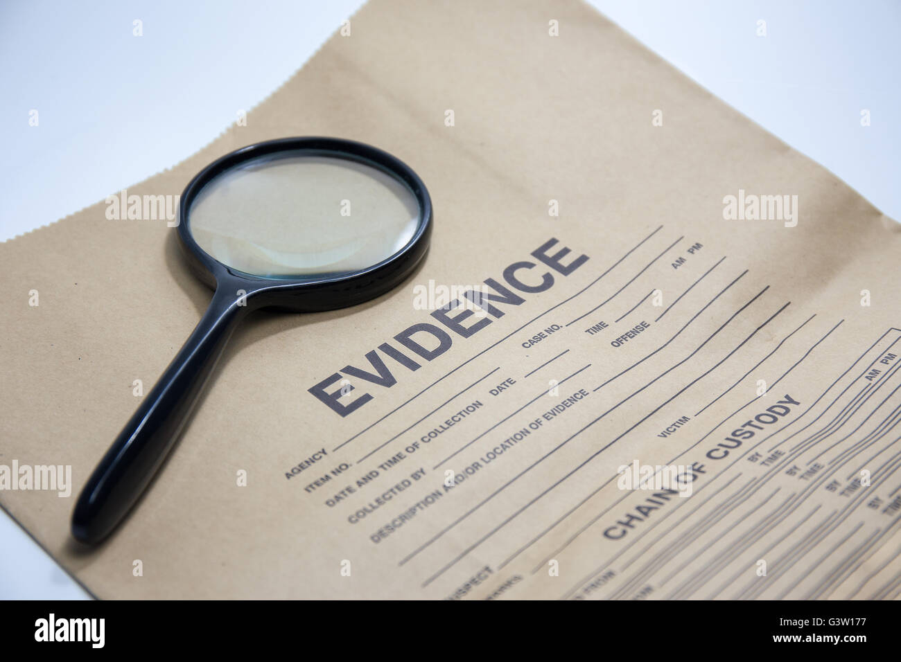 magnifying glass with evidence brown paper bag Stock Photo - Alamy
