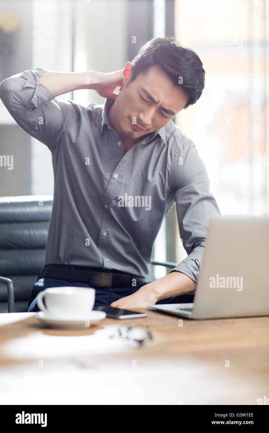 Tired young man working in office Stock Photo - Alamy