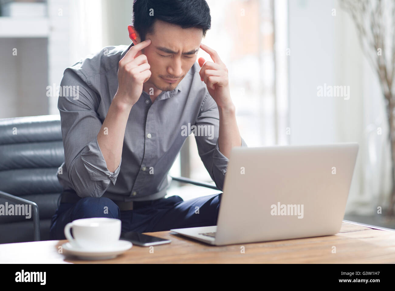Tired young man working in office Stock Photo - Alamy