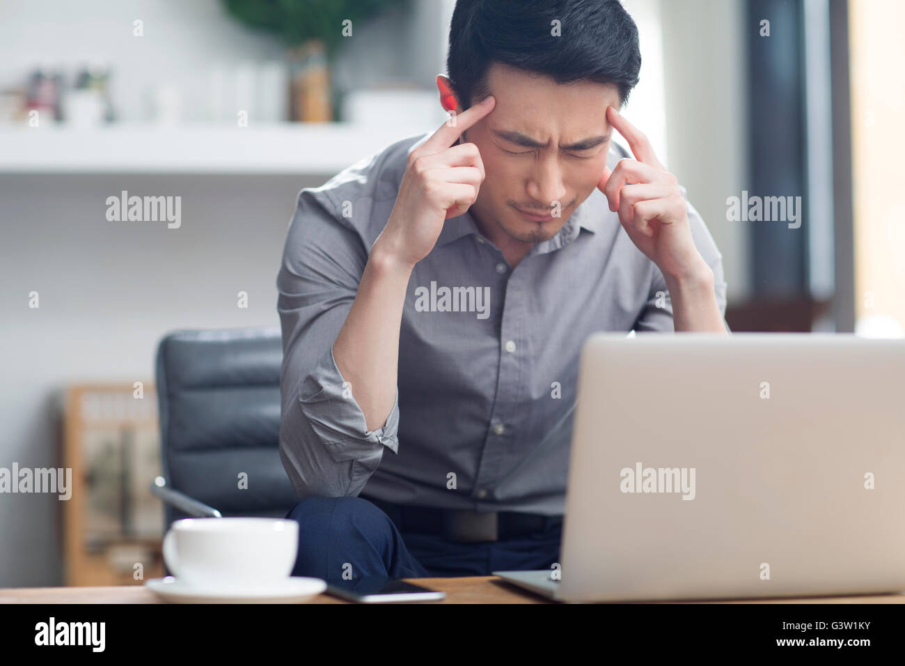 Tired young man working in office Stock Photo - Alamy