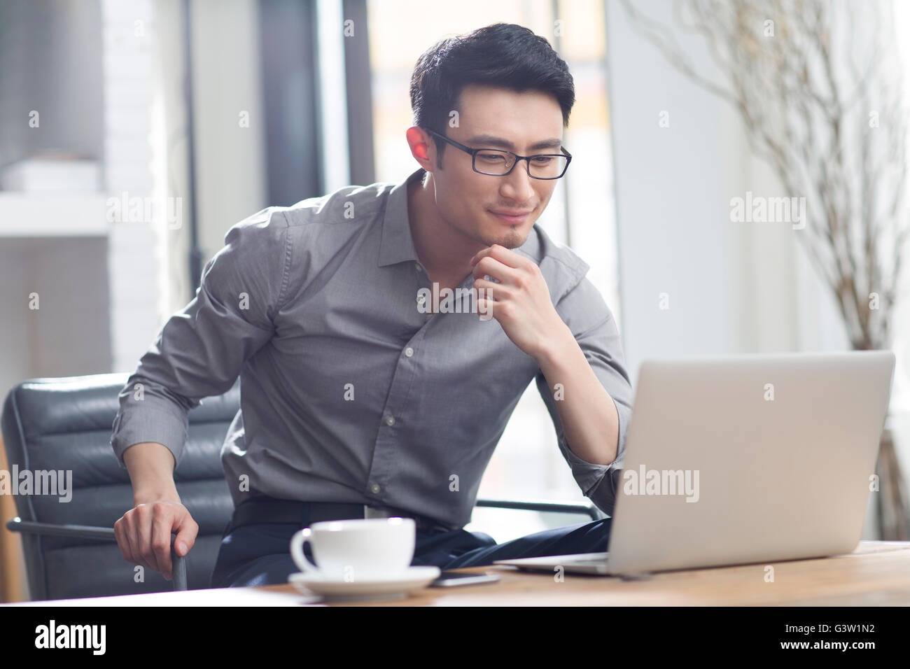 Young man working with laptop in office Stock Photo - Alamy