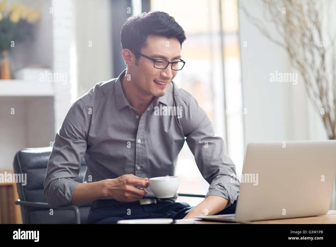 Young man working with laptop in office Stock Photo - Alamy