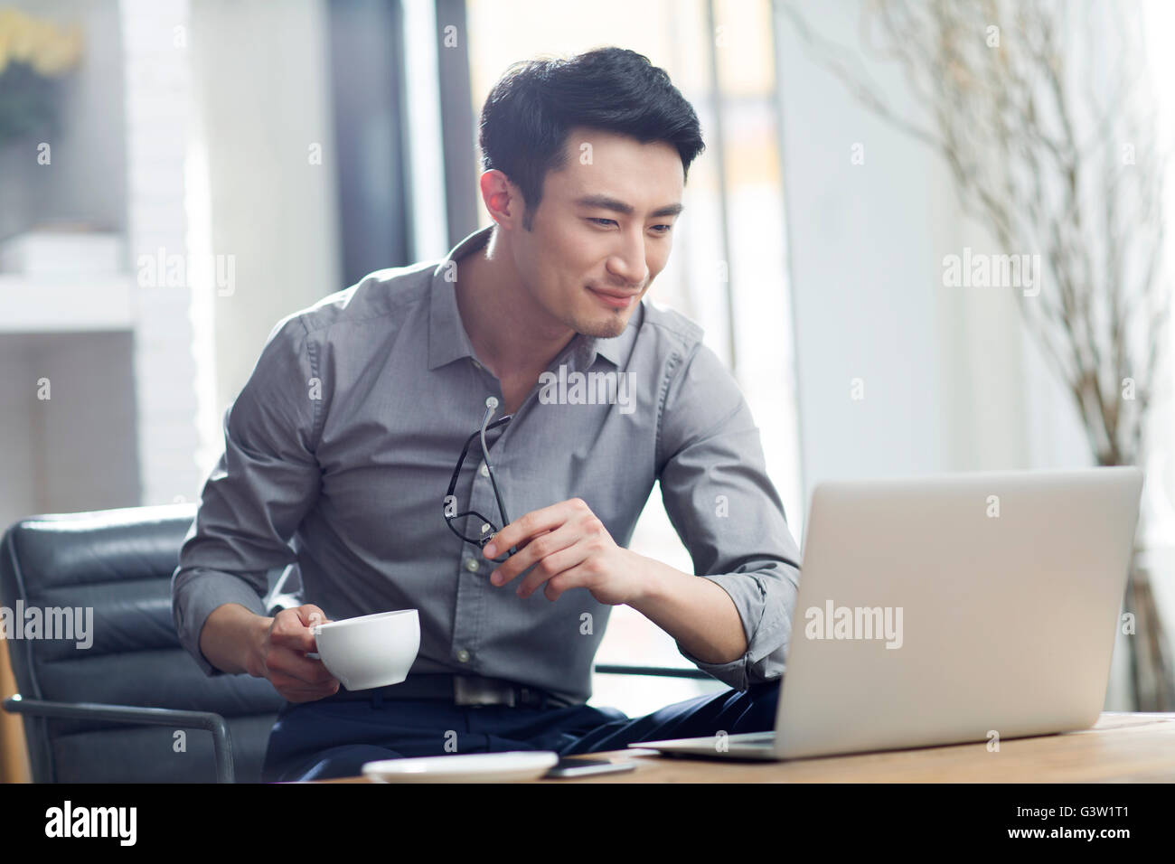 Young man working with laptop in office Stock Photo - Alamy