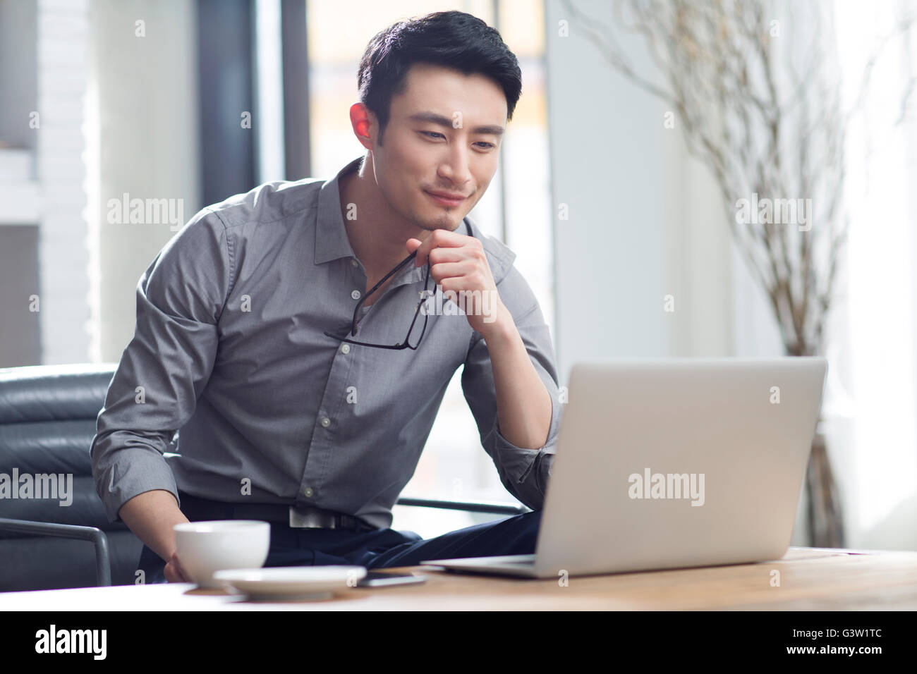 Young man working with laptop in office Stock Photo - Alamy