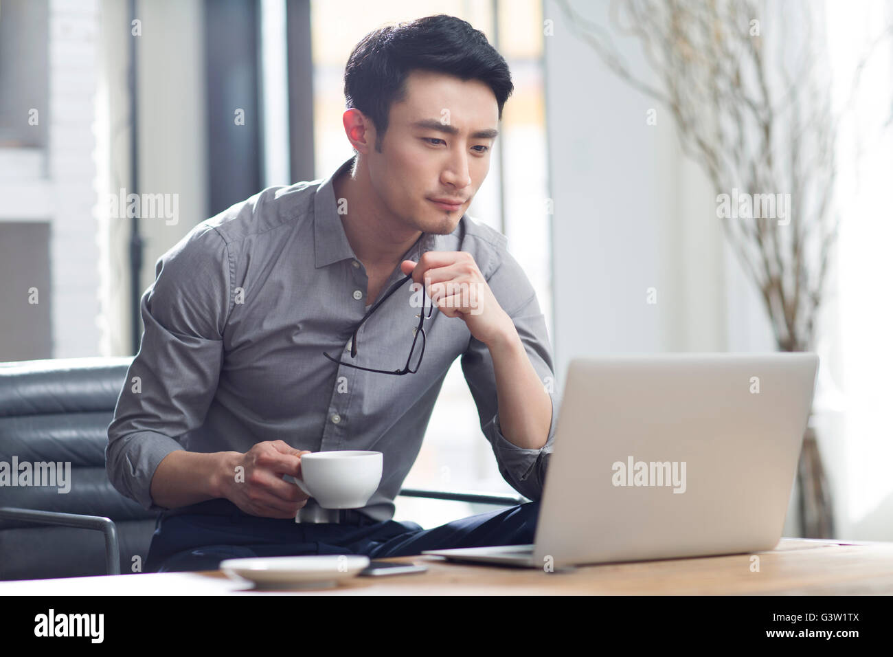 Young man working with laptop in office Stock Photo - Alamy