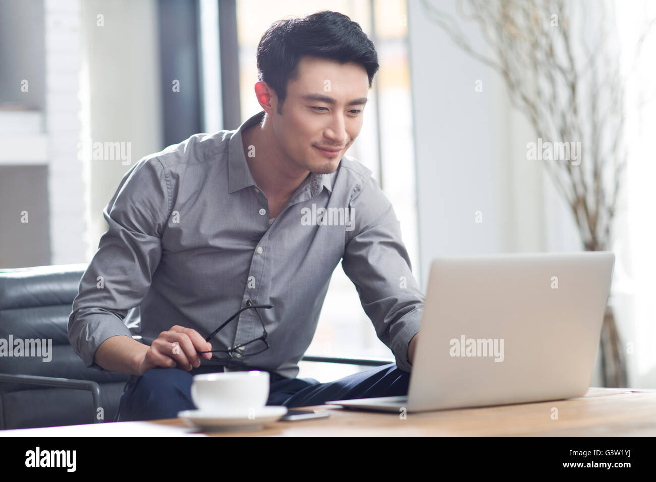 Young man working with laptop in office Stock Photo - Alamy