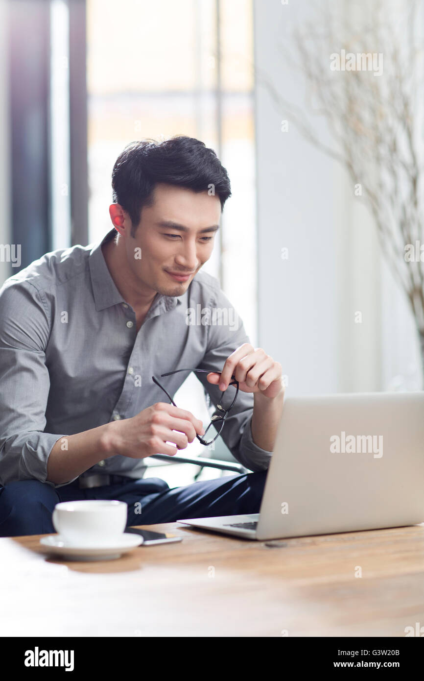 Young man working with laptop in office Stock Photo - Alamy