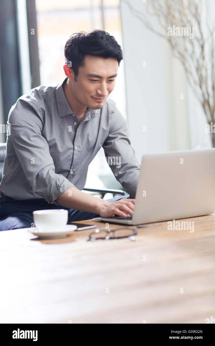 Young man working with laptop in office Stock Photo - Alamy