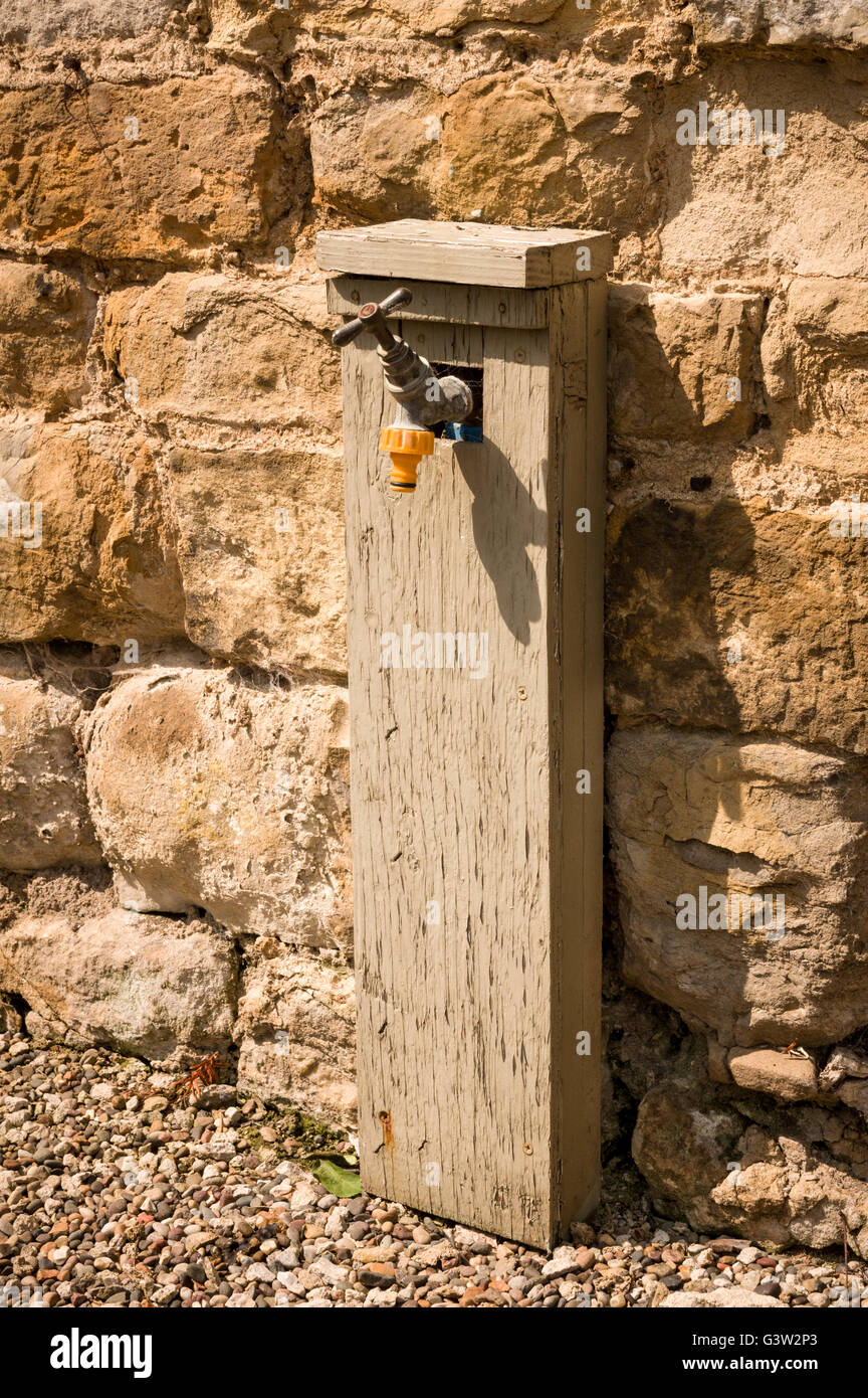 Traditional garden water tap with wood box casing Stock Photo - Alamy