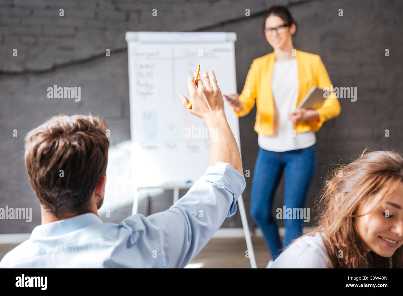Back view of young man sitting and asking questions on presentation in ...