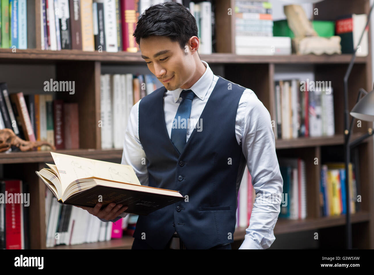 Young businessman reading book in his study Stock Photo - Alamy