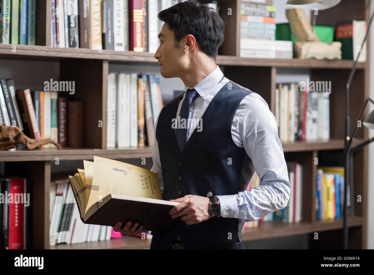 Young businessman reading book in his study Stock Photo - Alamy