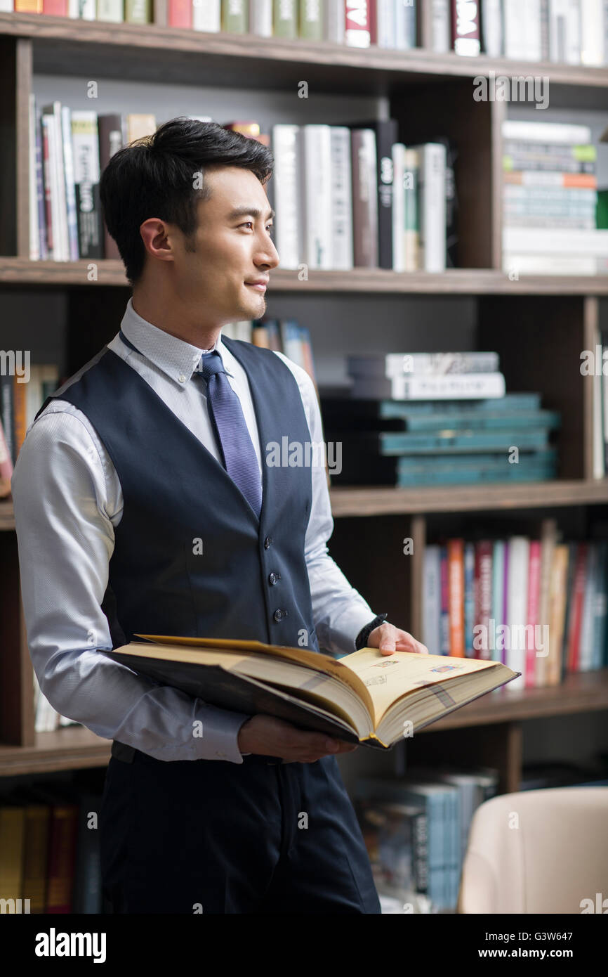 Young businessman reading book in his study Stock Photo - Alamy