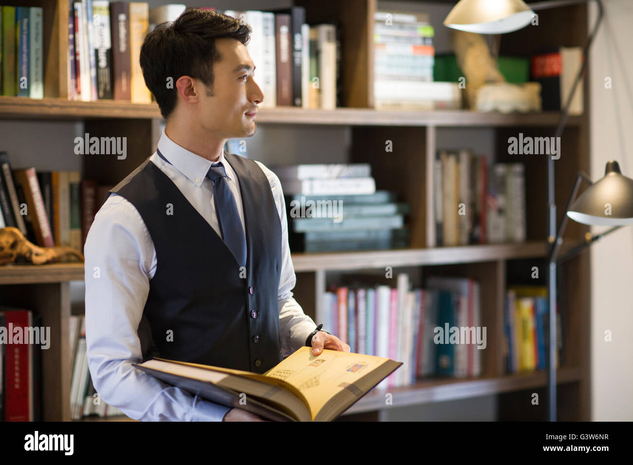 Young businessman reading book in his study Stock Photo - Alamy
