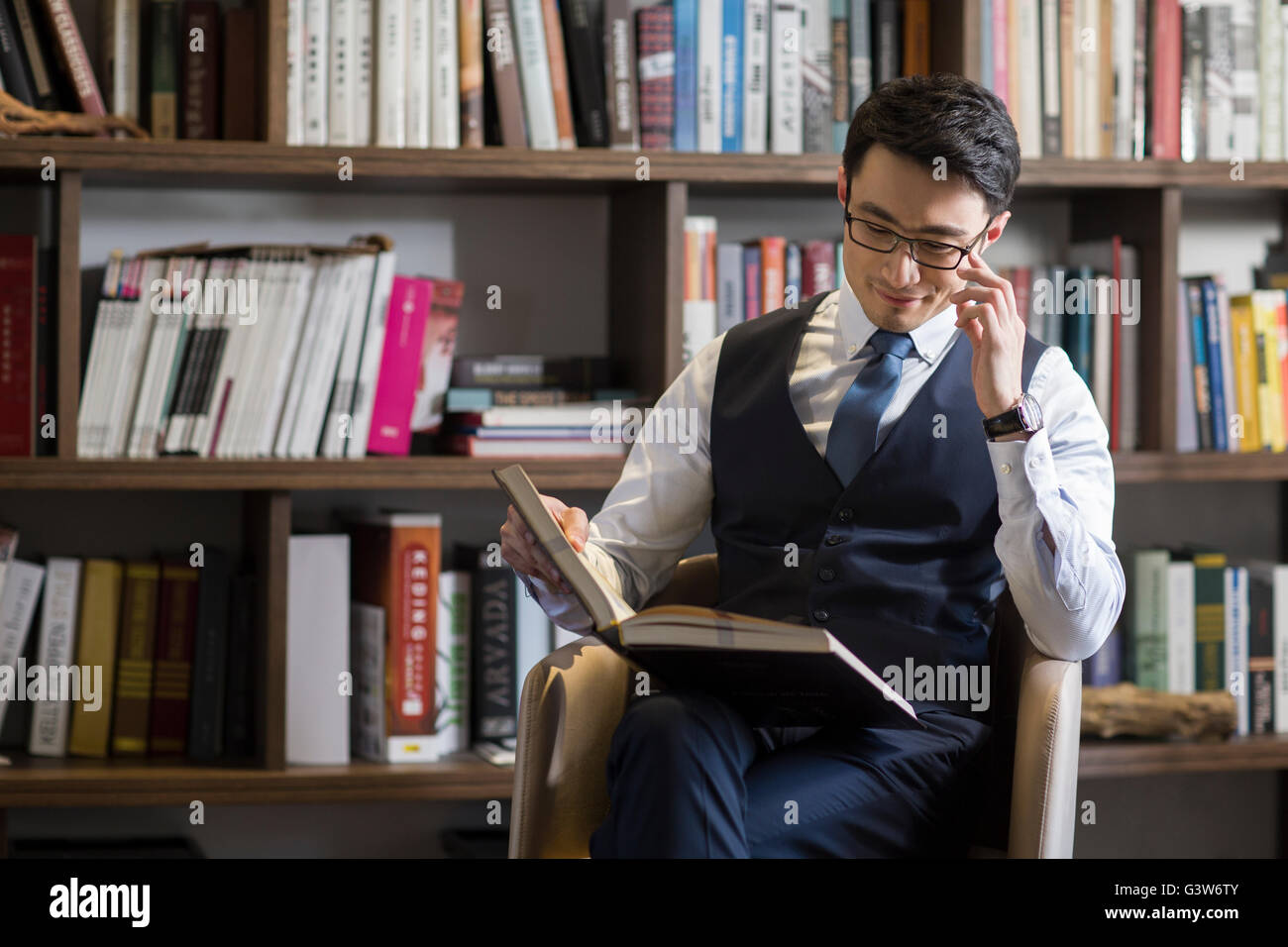 Young businessman reading book in his study Stock Photo - Alamy