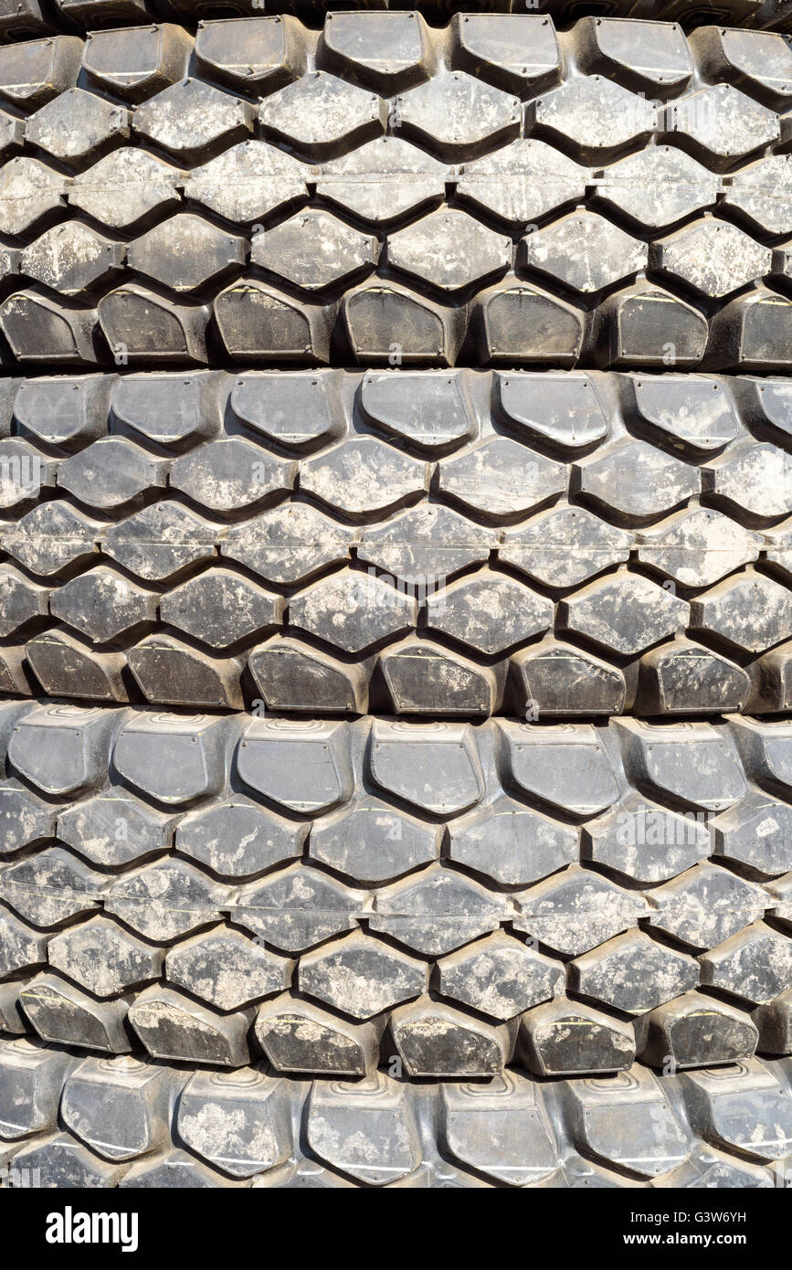 Stacked vehicle tyres lying on top of each other. Forming an abstract ...