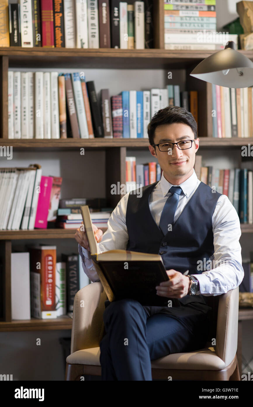 Young businessman reading book in his study Stock Photo - Alamy