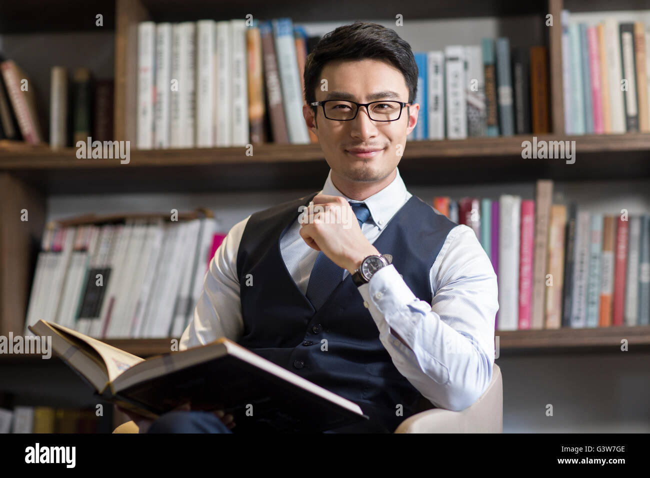 Young businessman reading book in his study Stock Photo - Alamy