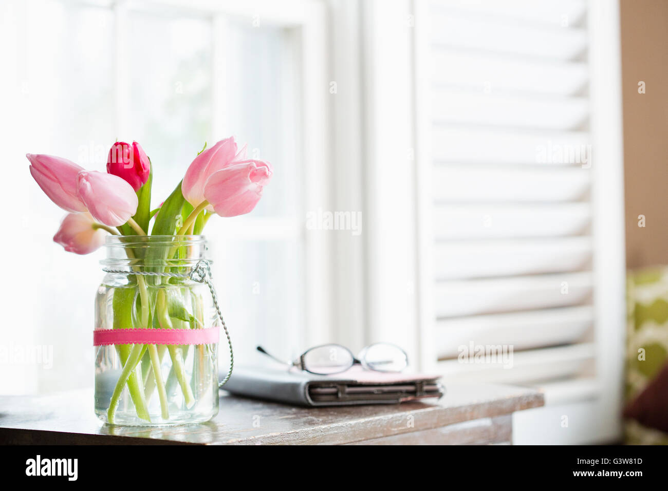 Pink tulips in vase on night table Stock Photo - Alamy