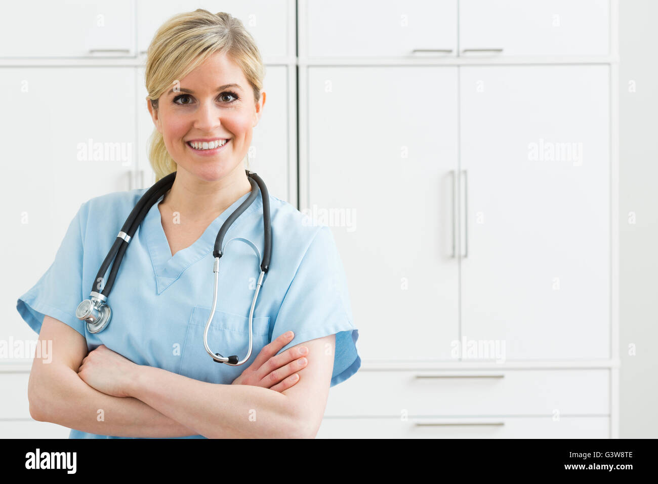 Portrait of female nurse standing with arms crossed Stock Photo - Alamy