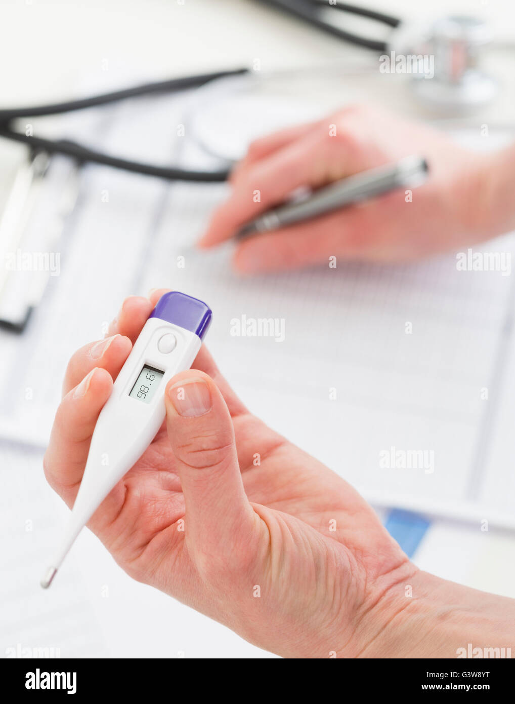 Hand holding thermometer Stock Photo - Alamy