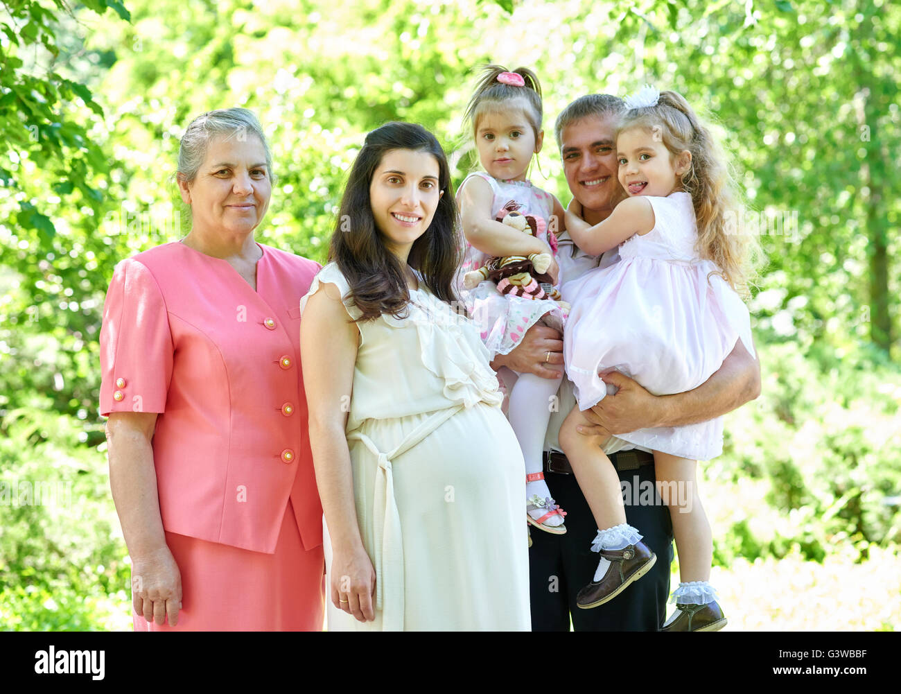 big family and pregnant woman in city park, summer season, green grass ...
