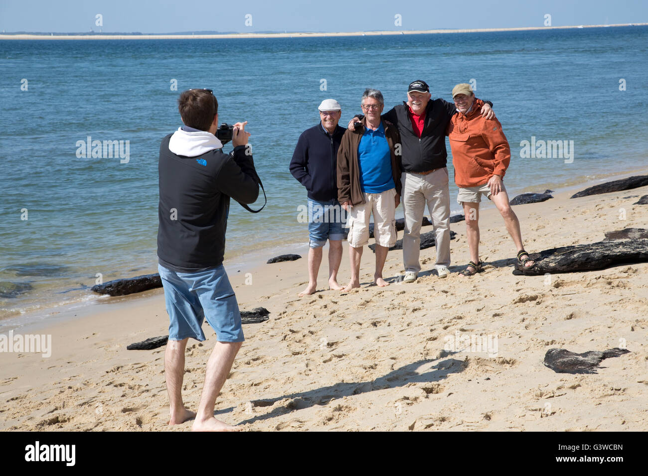 Man taking photo of group of four smiling men Dune of Pyla Southern ...